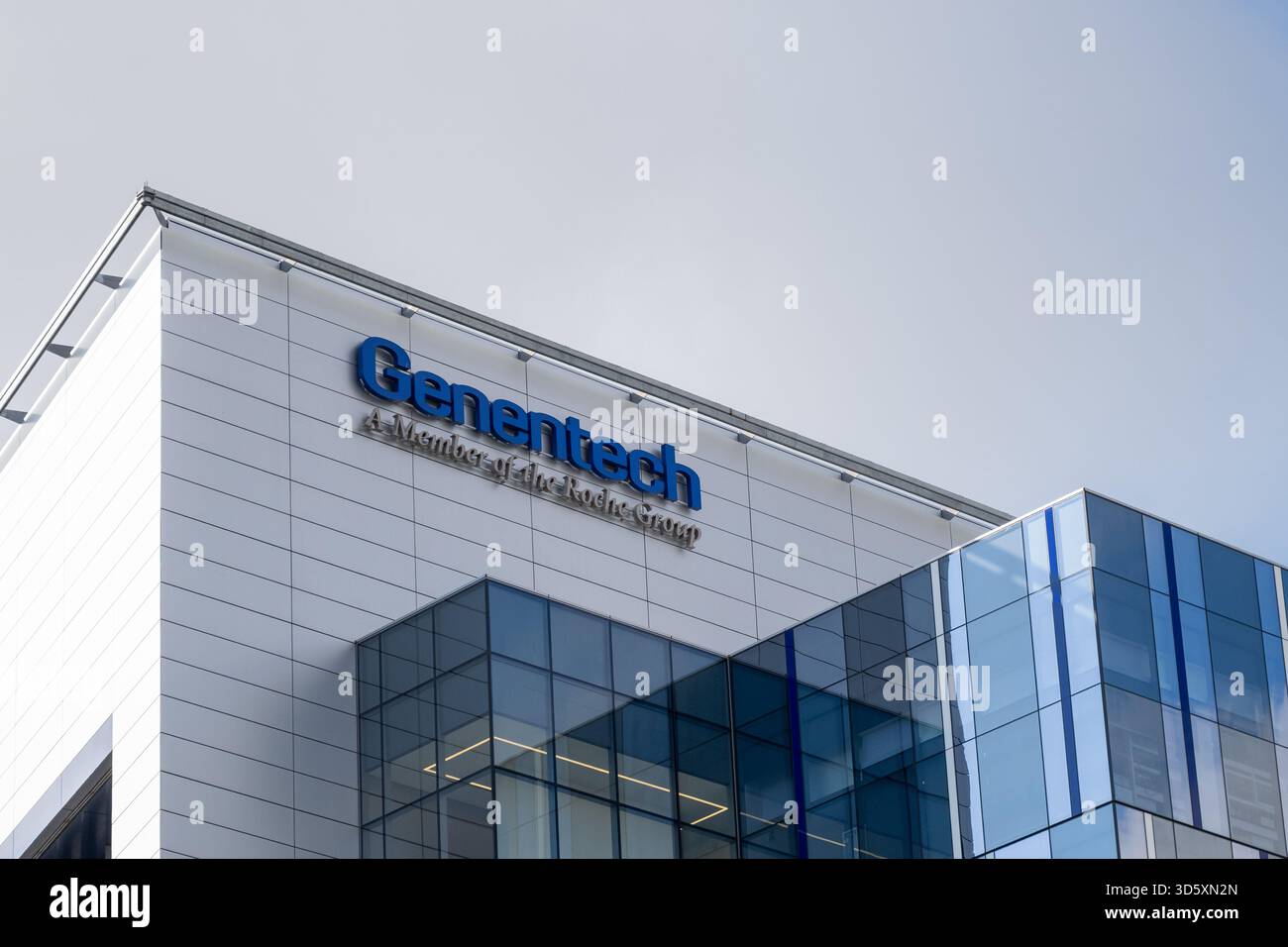 Genentech campus building with company logo and modern glass facade under cloudy sky, South San ...