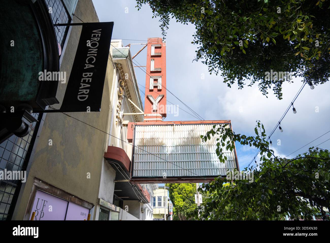 Vertical CLAY sign and blank theater marquee above sidewalk with Veronica Beard storefront sign ...