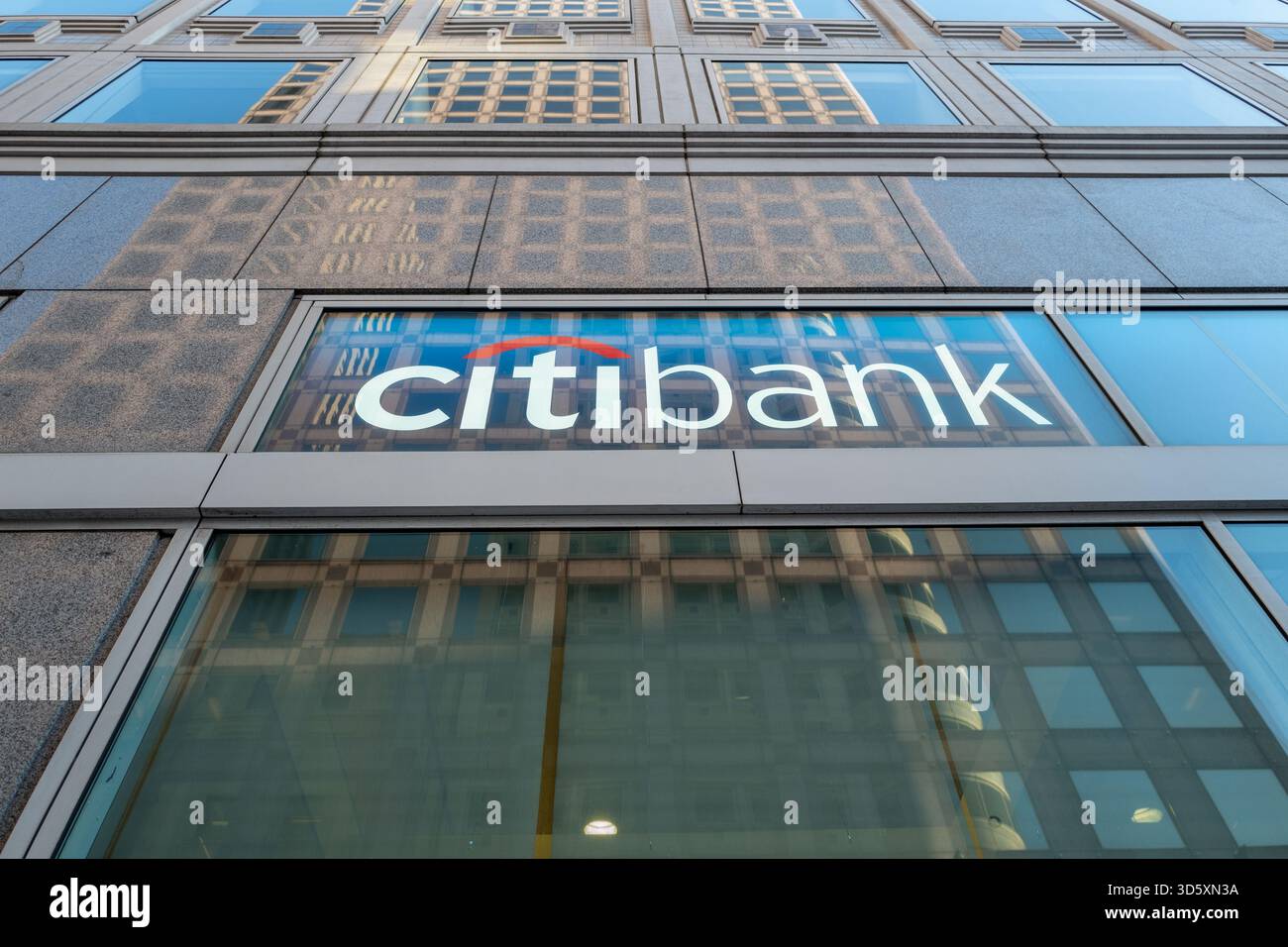 Low-angle view of Citibank sign on building, with reflections visible ...
