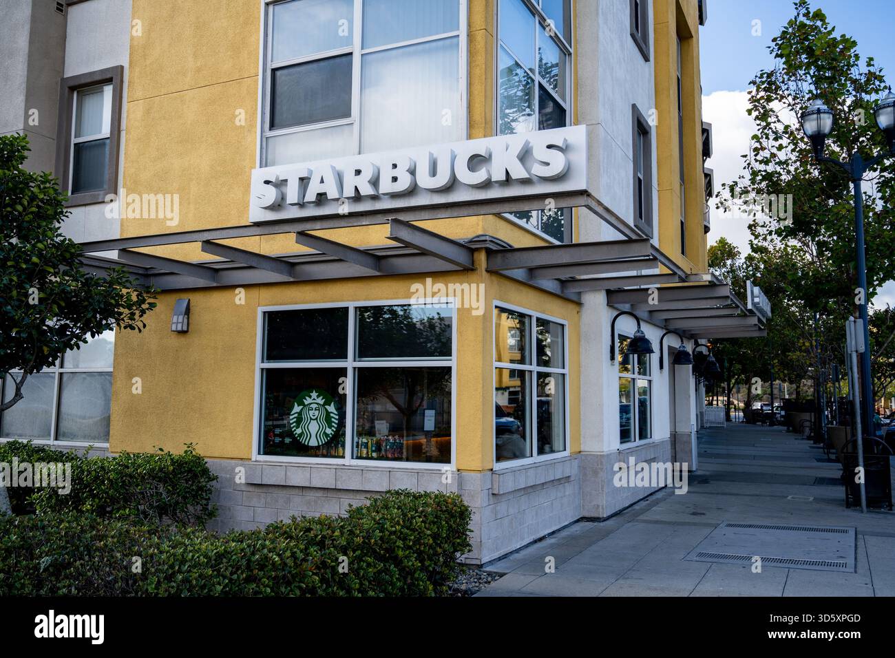 Corner storefront of Starbucks coffee shop with sign and window logo on ...