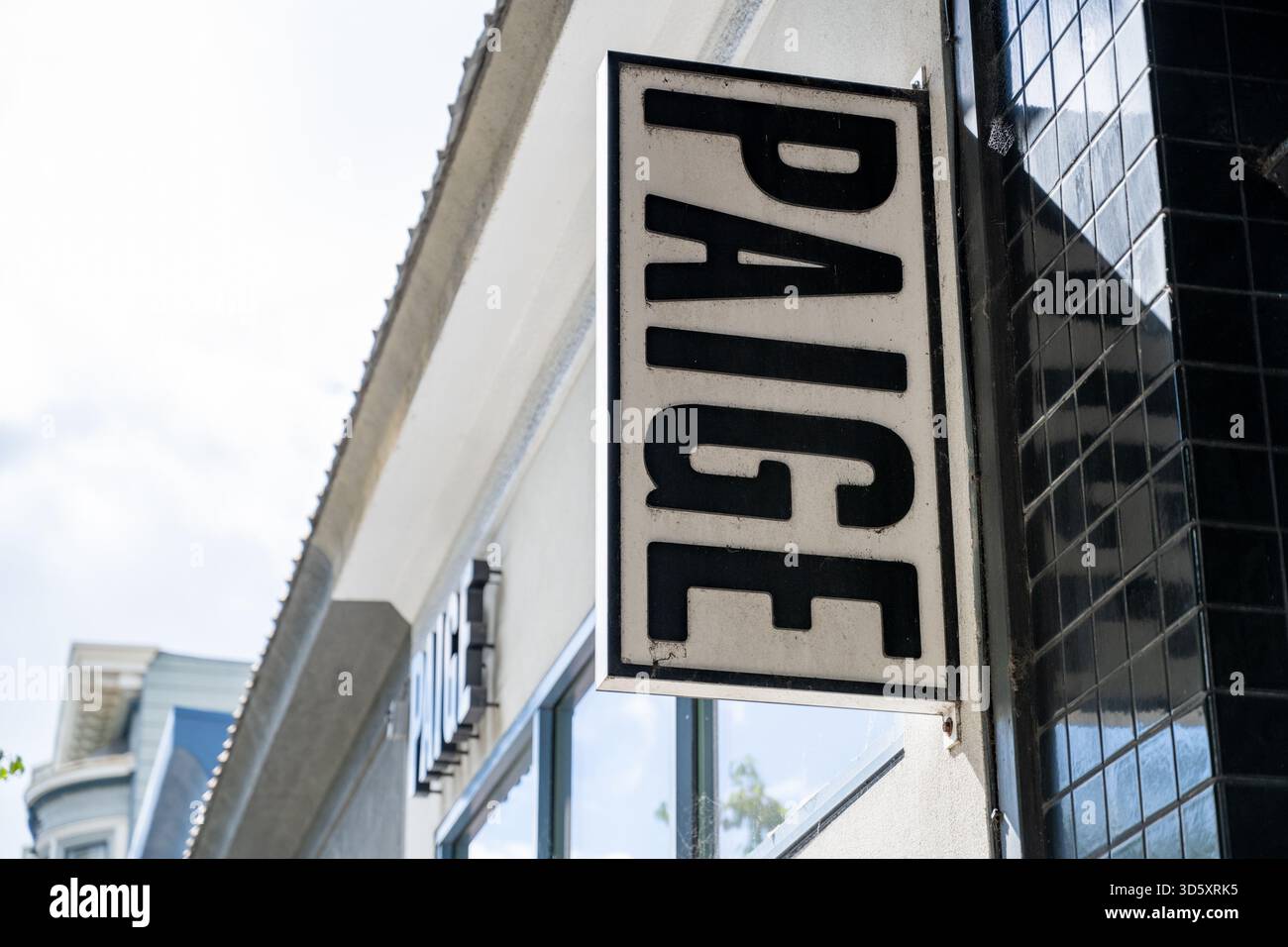 Retail storefront sign for Paige clothing store with black tile facade ...