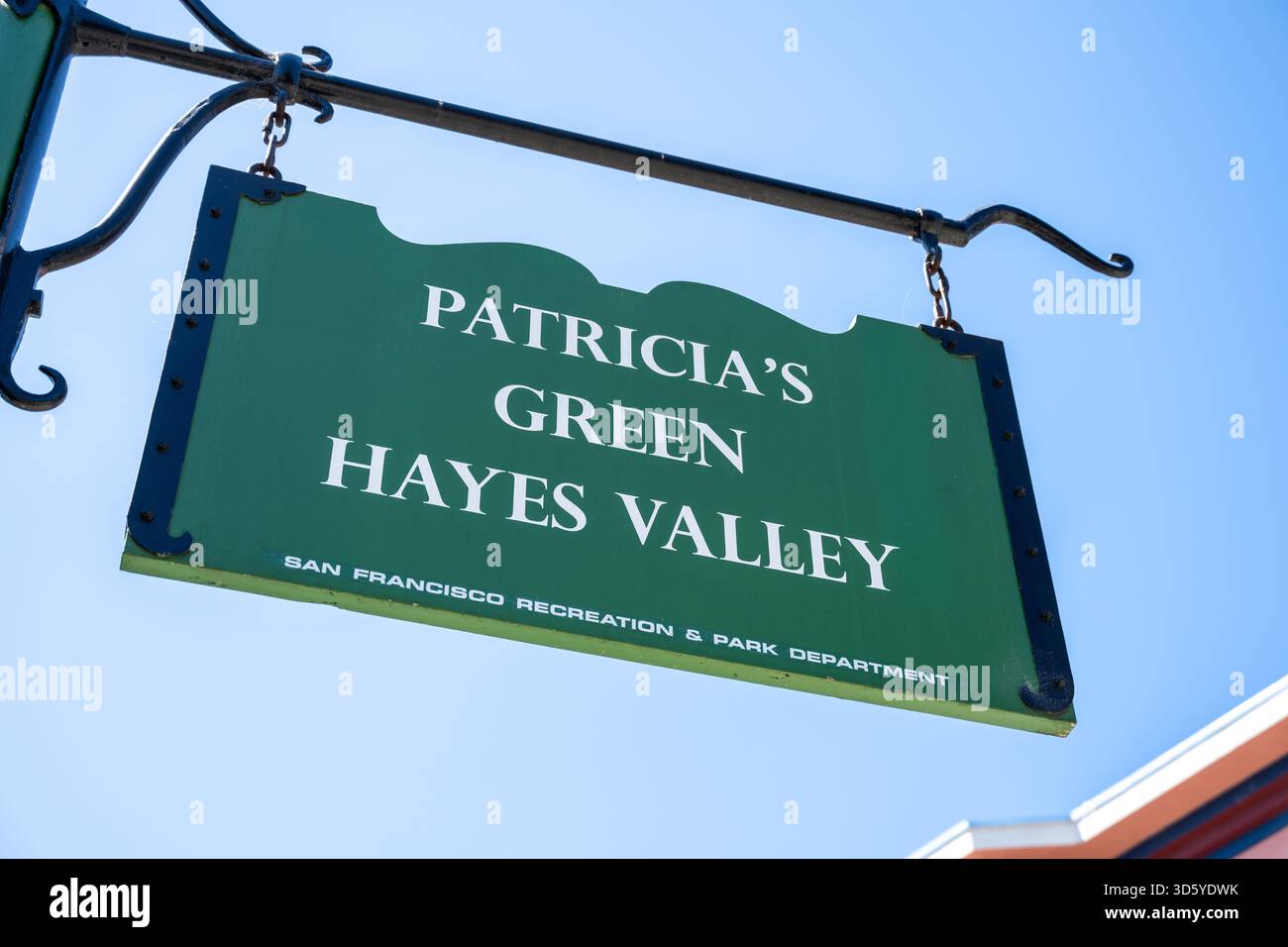 Patricia's Green park sign hanging from metal bracket against clear ...