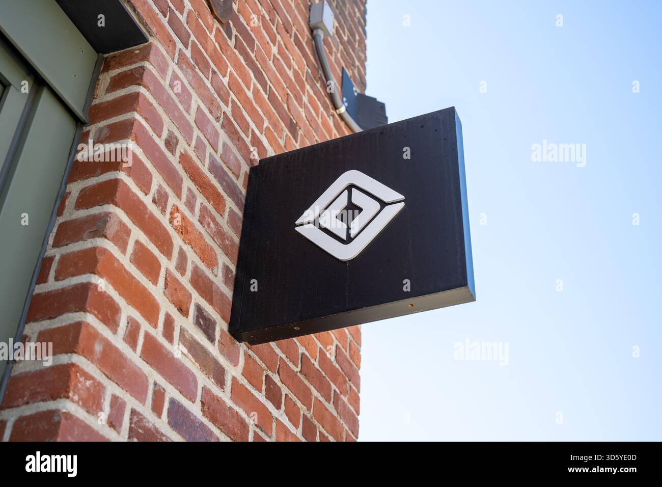 Rivian logo sign on brick building facade under clear blue sky, San ...
