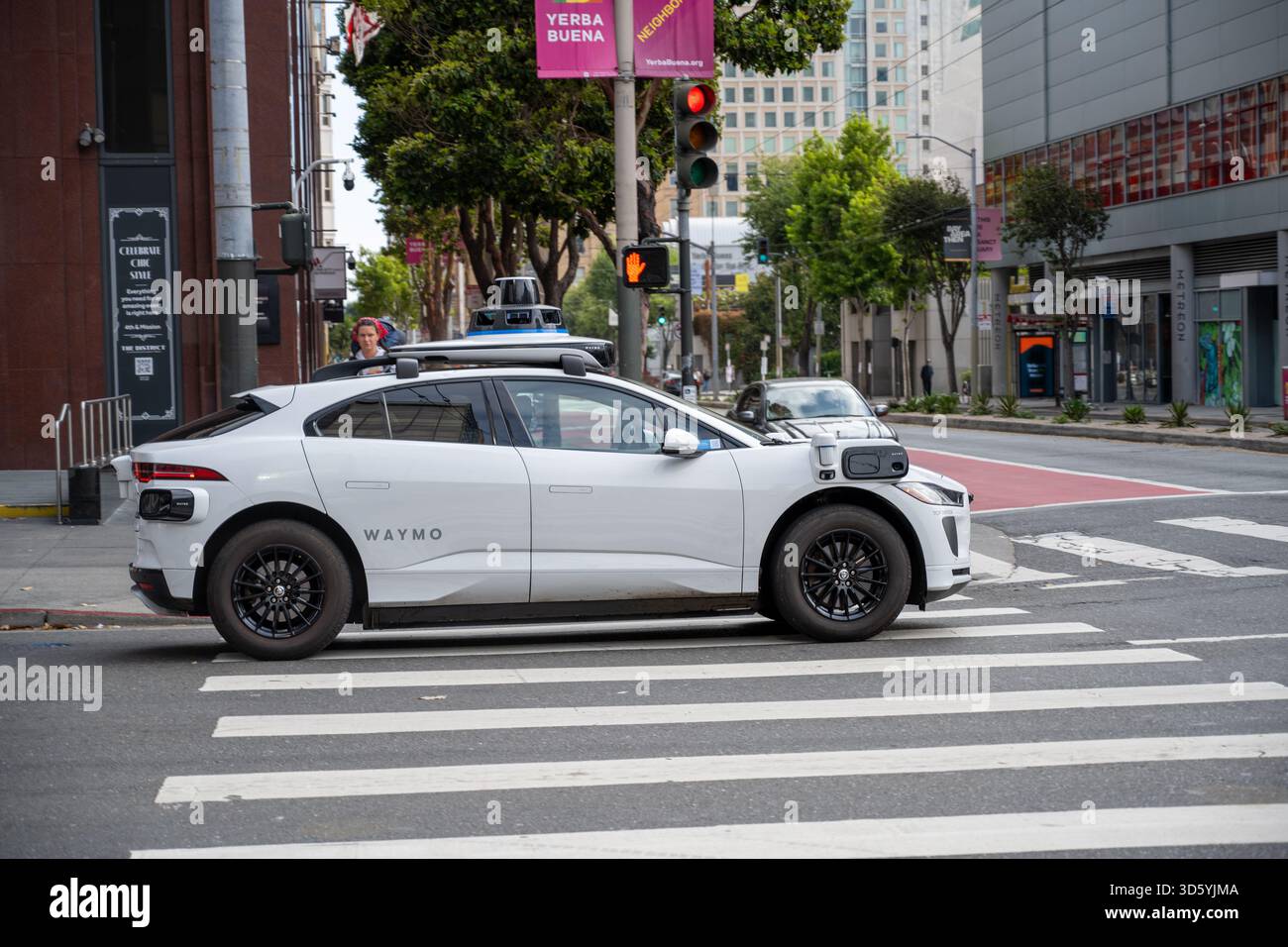 Waymo self-driving car with roof-mounted sensors stopped at crosswalk ...