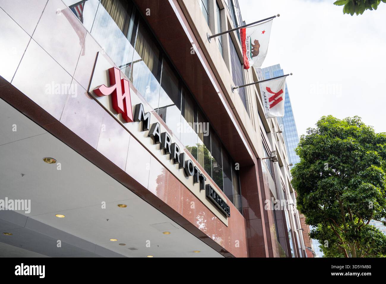 Facade of Marriott Marquis hotel with logo signage and flags on a city ...