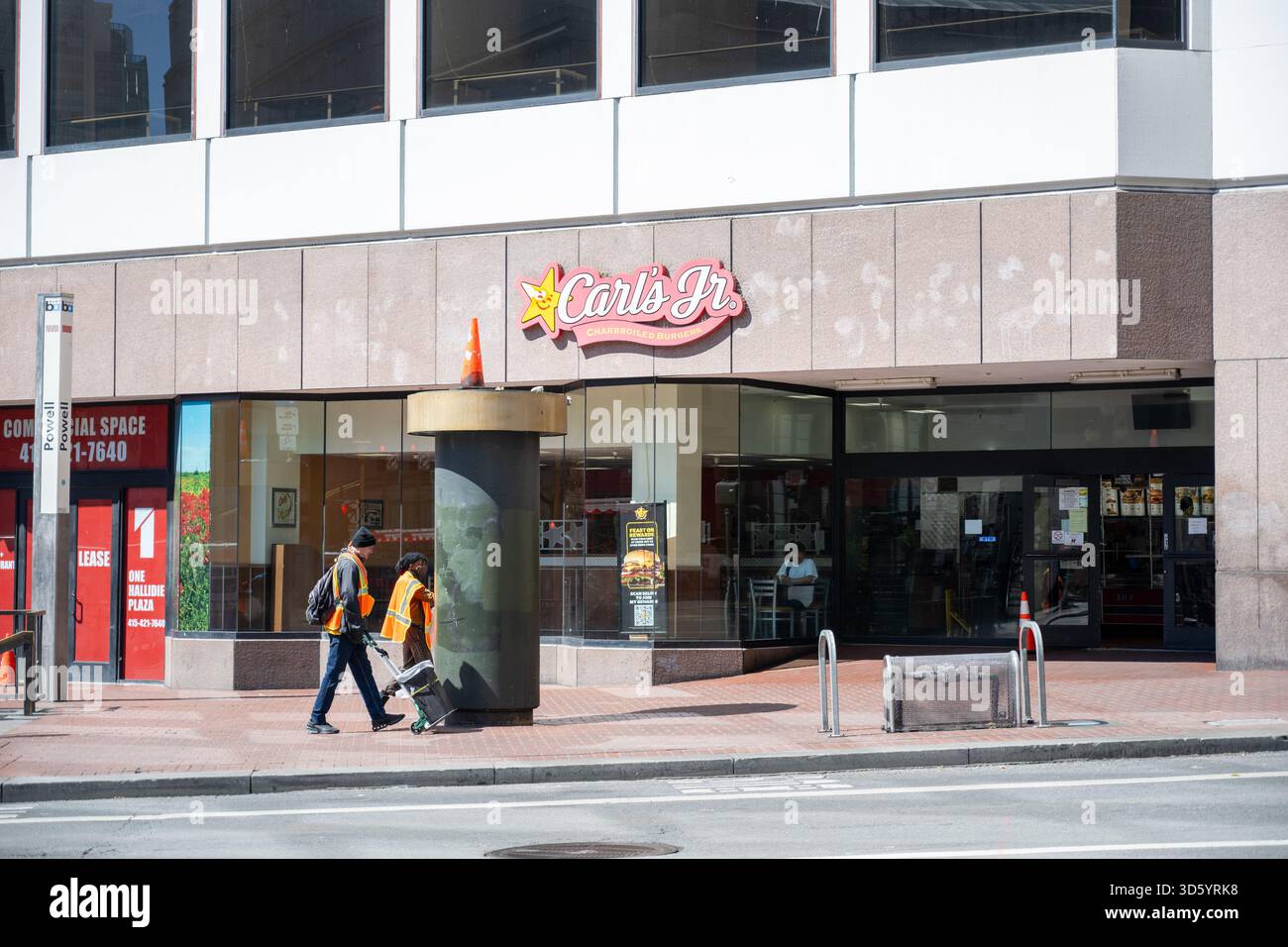 Facade of Carl's Jr fast food restaurant with two workers in orange ...