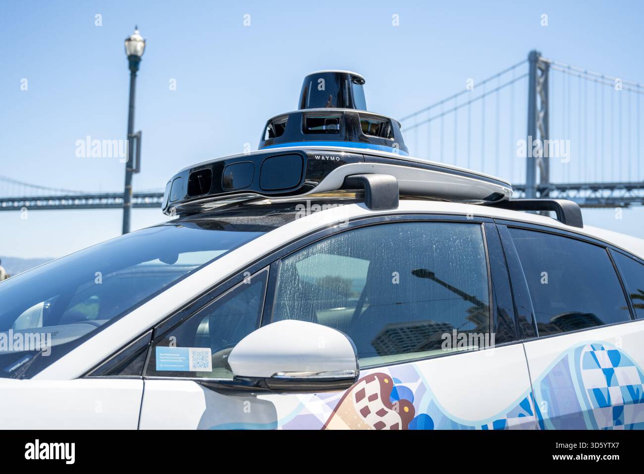 Self-driving Waymo car with rooftop lidar and bird-themed mural on the ...