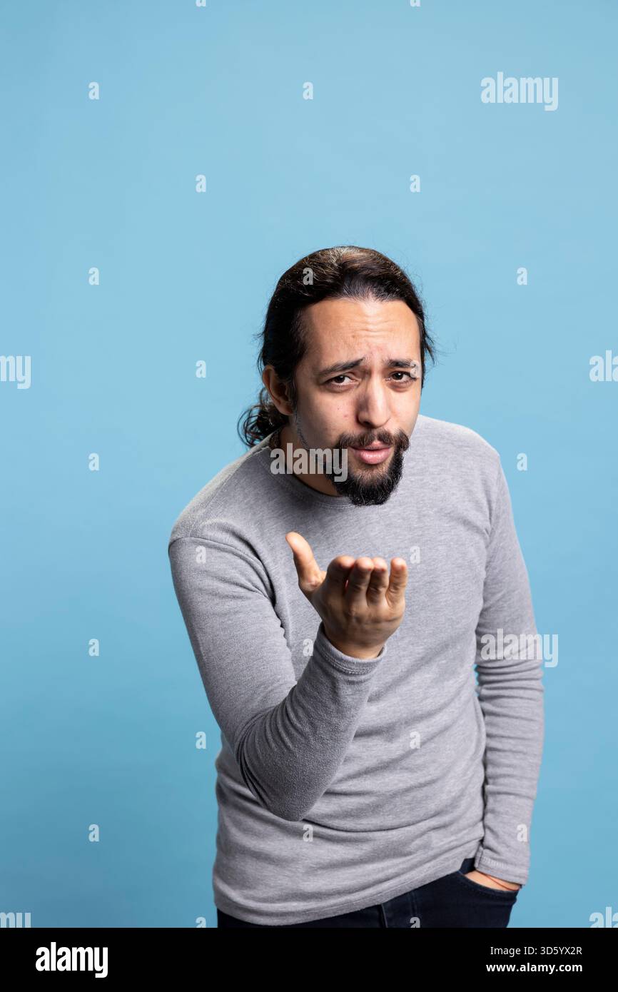 Young romantic person with long hair blowing air kisses in studio ...