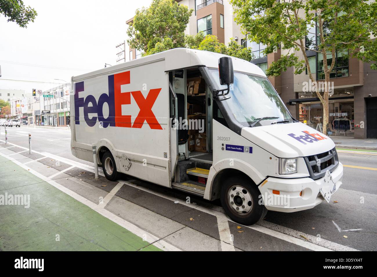 FedEx delivery truck with side door open and packages visible, parked ...