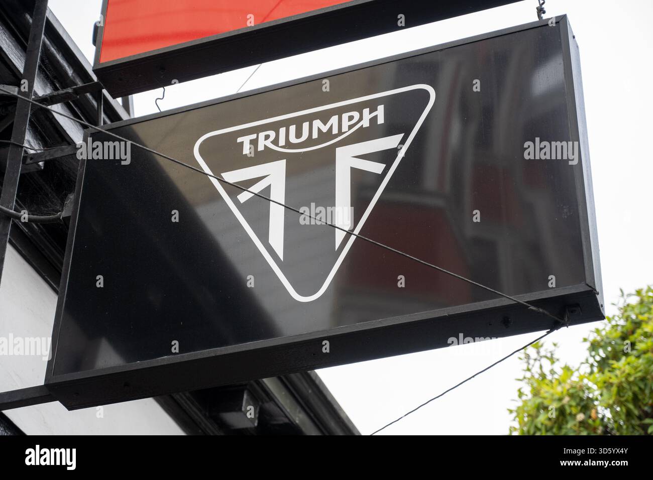 Hanging storefront sign with Triumph logo, black panel with white ...