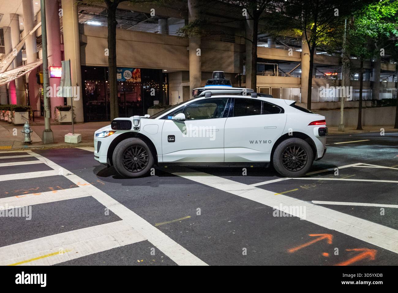 Waymo self driving car navigates a street at night in downtown Atlanta ...