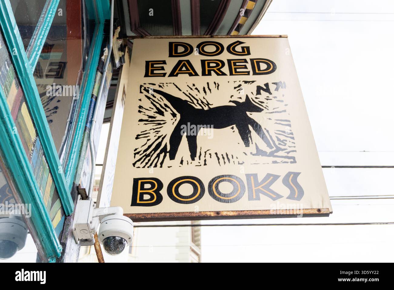 Hanging sign for Dog Eared Books bookstore with black dog graphic and ...