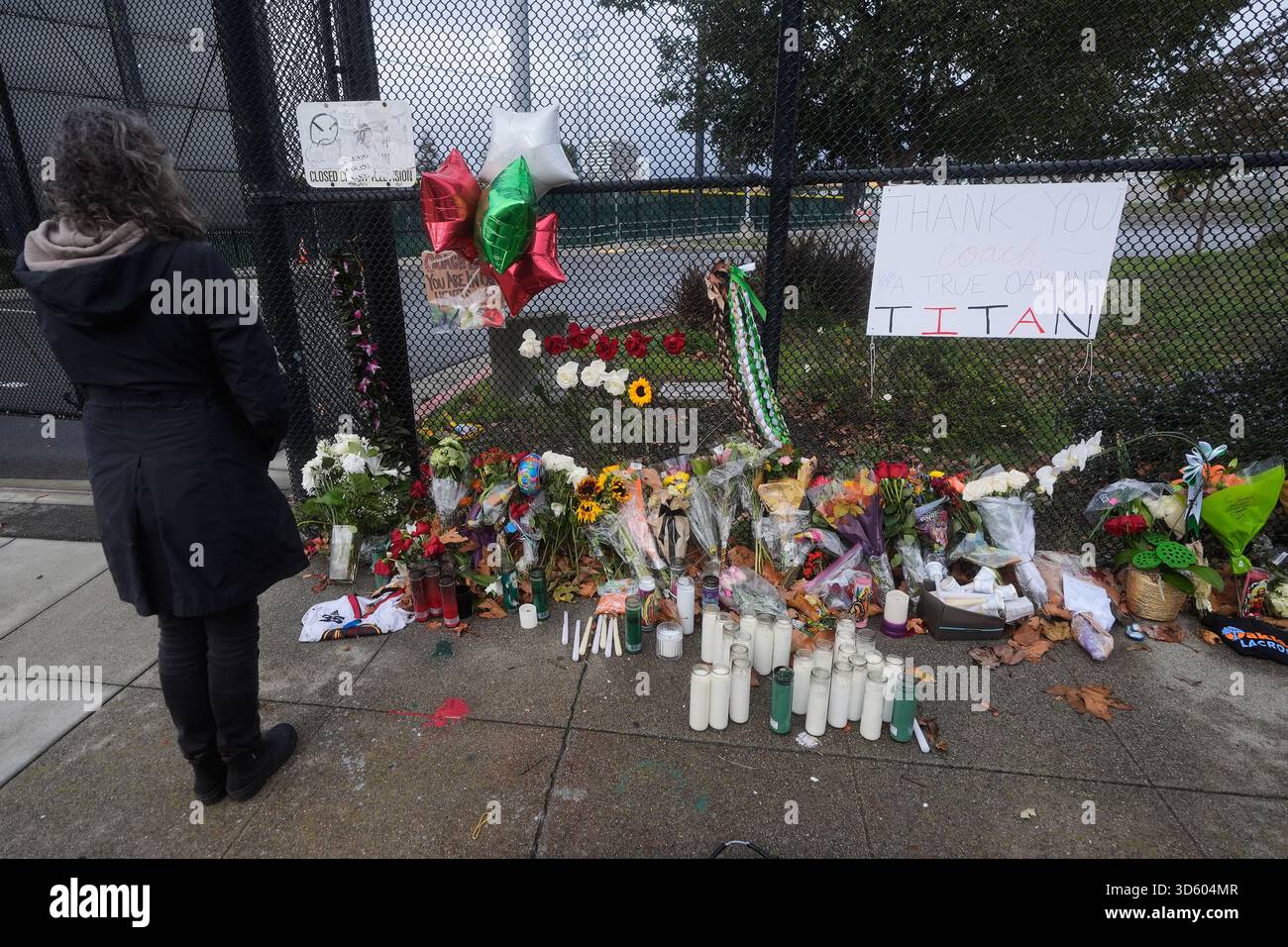Jayne Moser looks at a sidewalk memorial for former football coach John ...