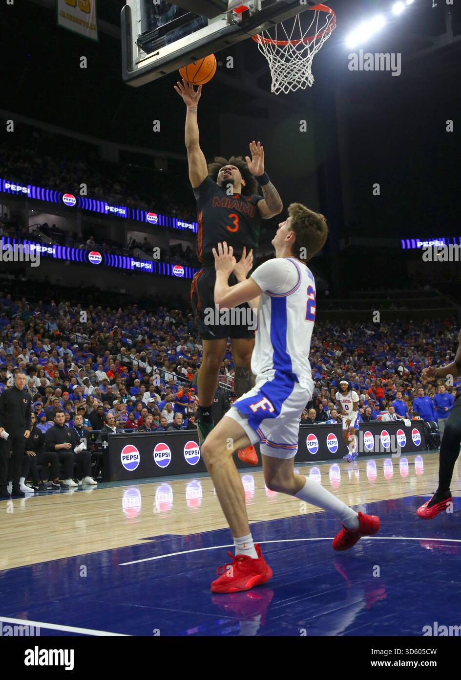 Miami's Tre Donaldson, (3), goes up against Florida's Alex Condon, (21 ...