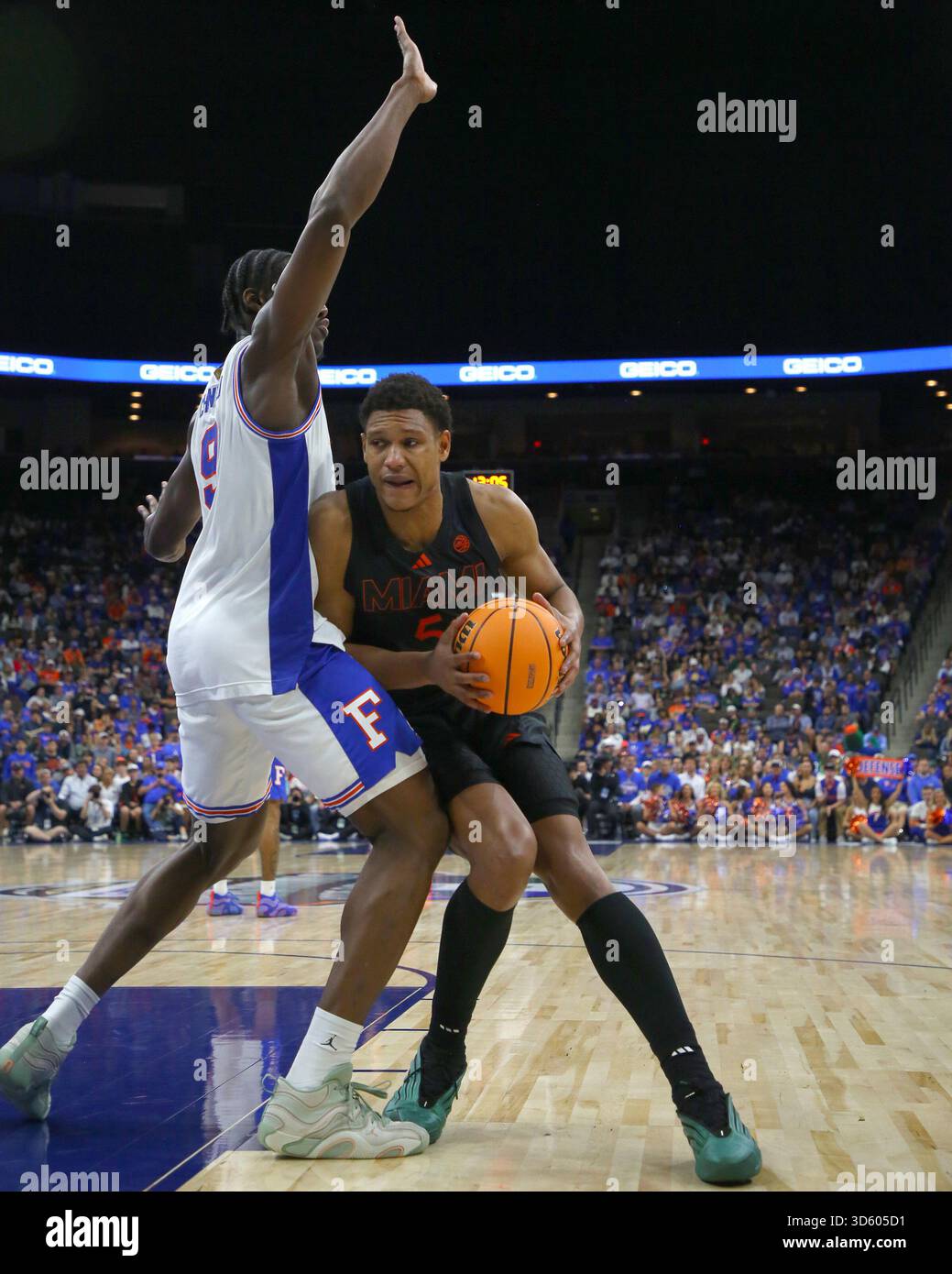 Miami's Malik Reneau, (5), drives against Florida's Rueben Chinyelu, (9 ...