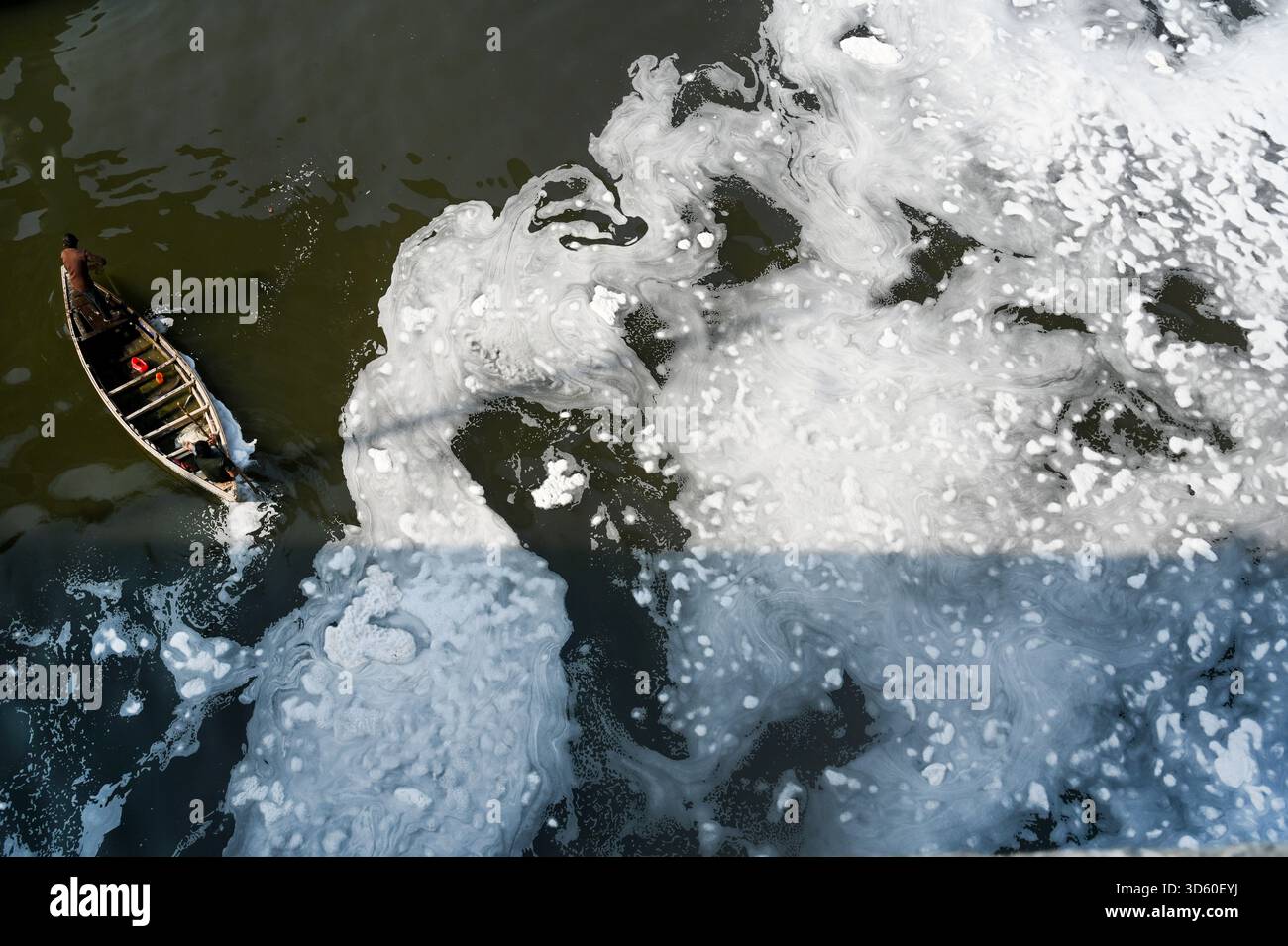 NEW DELHI, INDIA - NOVEMBER 17: Fisherman fishing in the toxic foam of ...