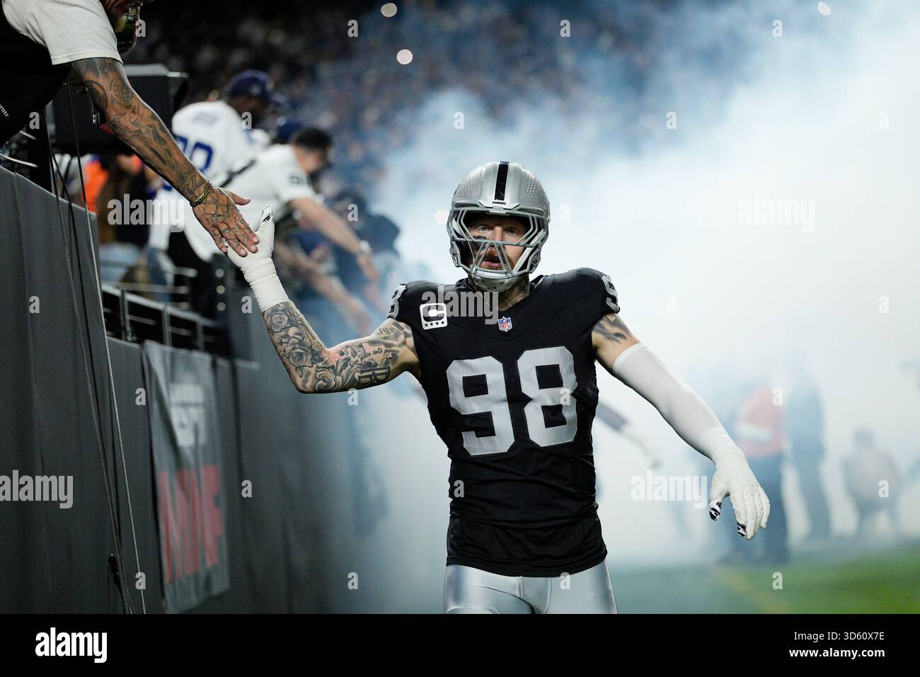 Las Vegas Raiders defensive end Maxx Crosby gets a high-five from a fan ...