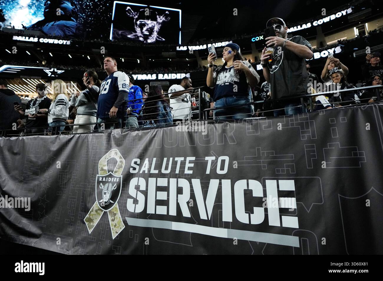 Las Vegas Raiders fans stand behind the NFL Salute to Service logo ...