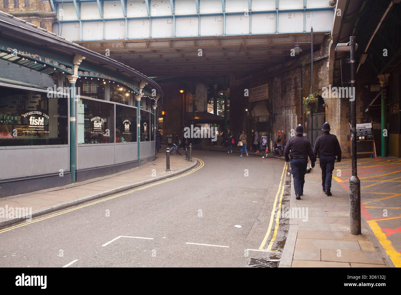 Two Typical british police officers walking under a bridge in Southwark ...