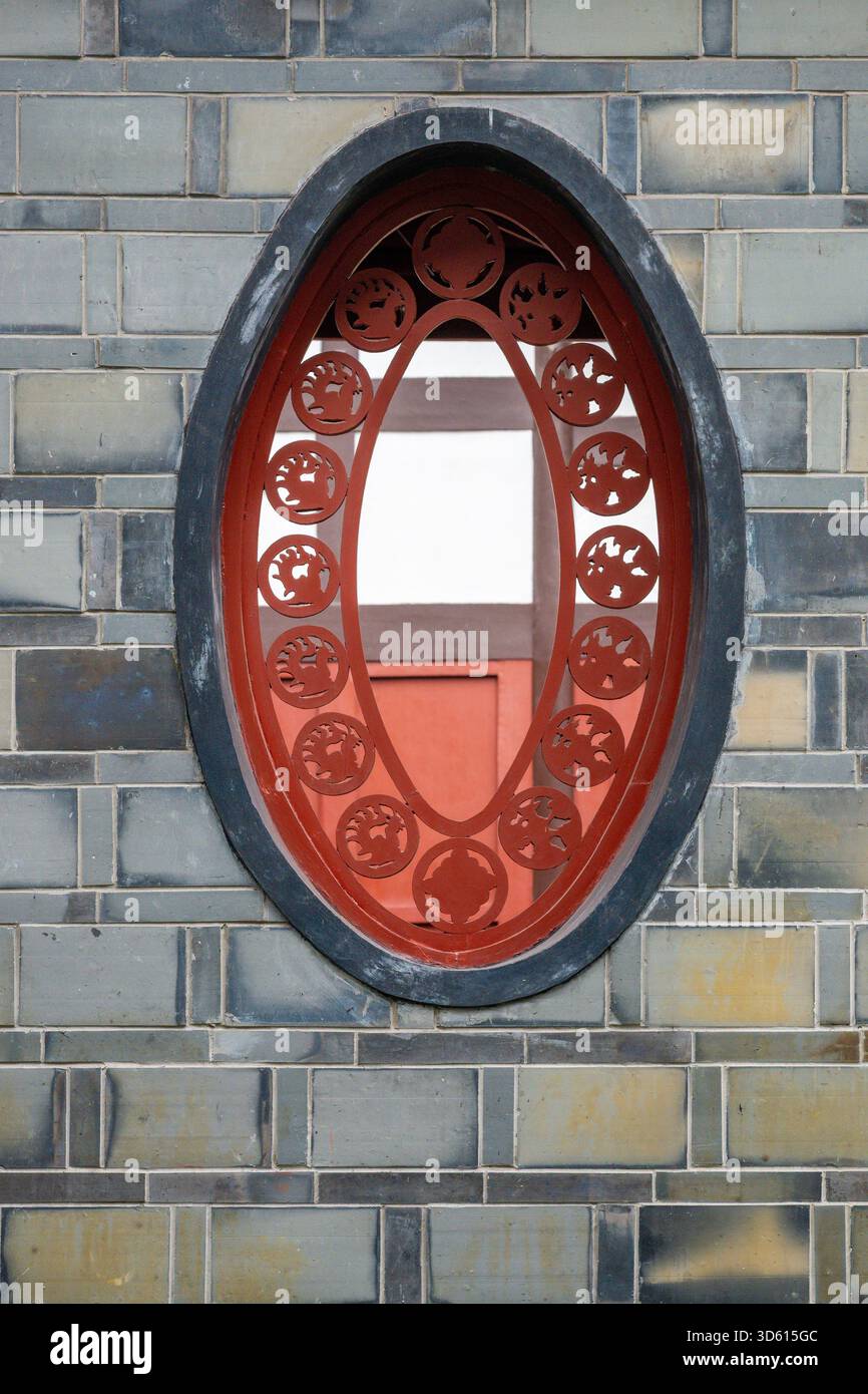 This view features an oval-shaped window set in a brick wall ...
