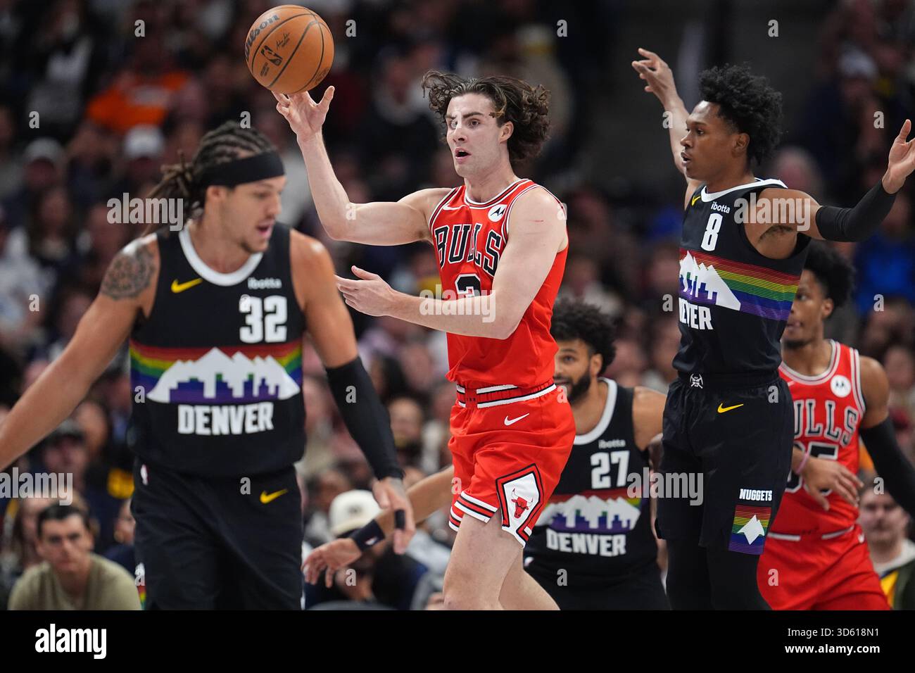 Chicago Bulls guard Josh Giddey, center, passes the ball as Denver Nuggets forward Aaron Gordon ...