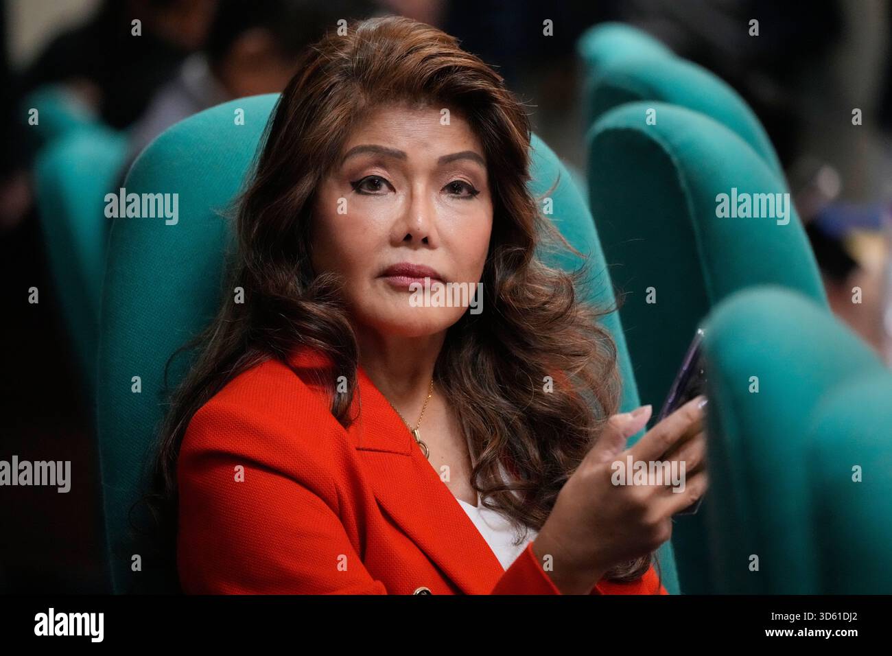 Senator Imee Marcos checks her phone during a break at a Senate hearing in Manila, Philippines ...