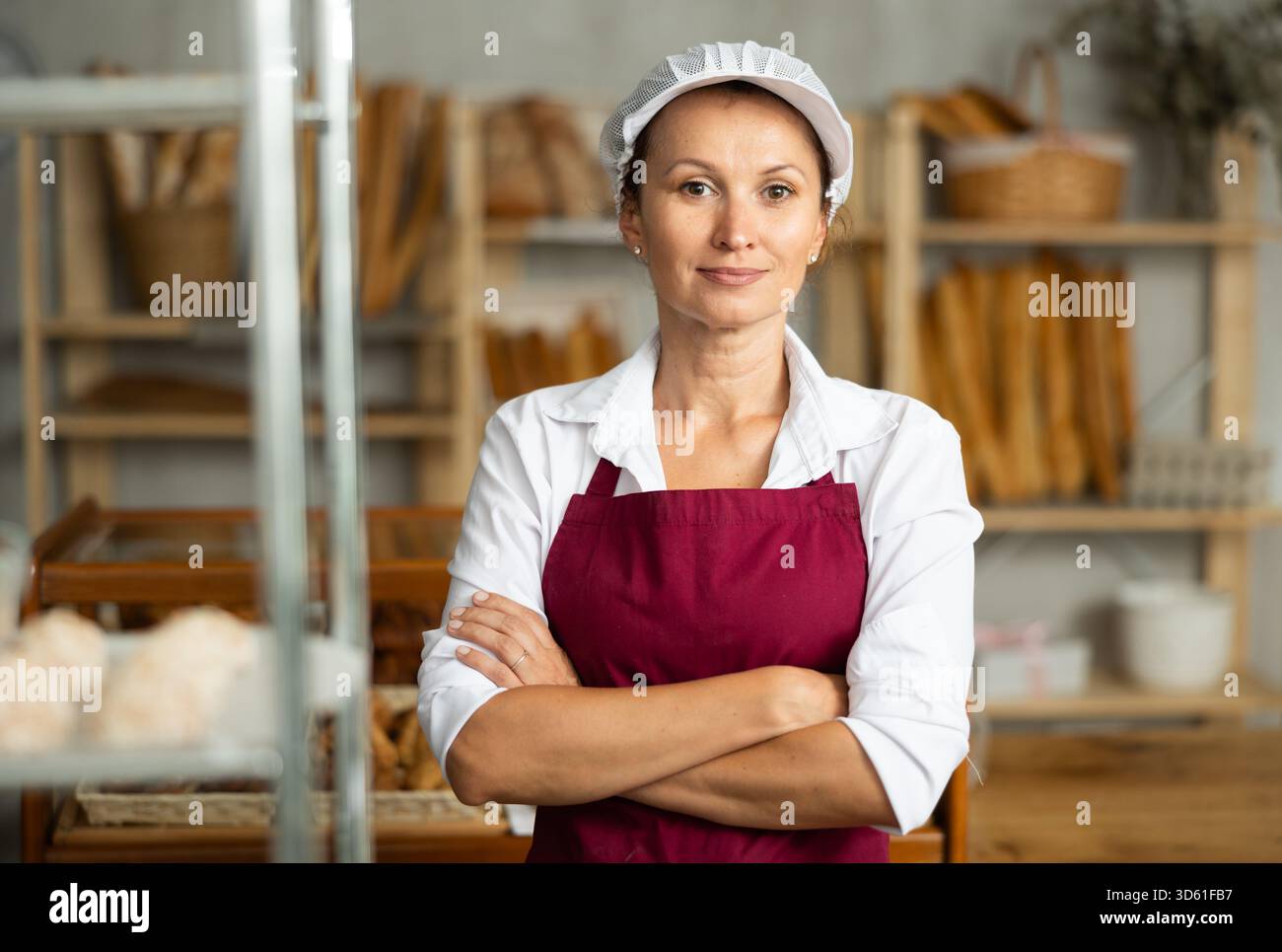 Woman baker in white coat overall and cap stands in trading hall of ...