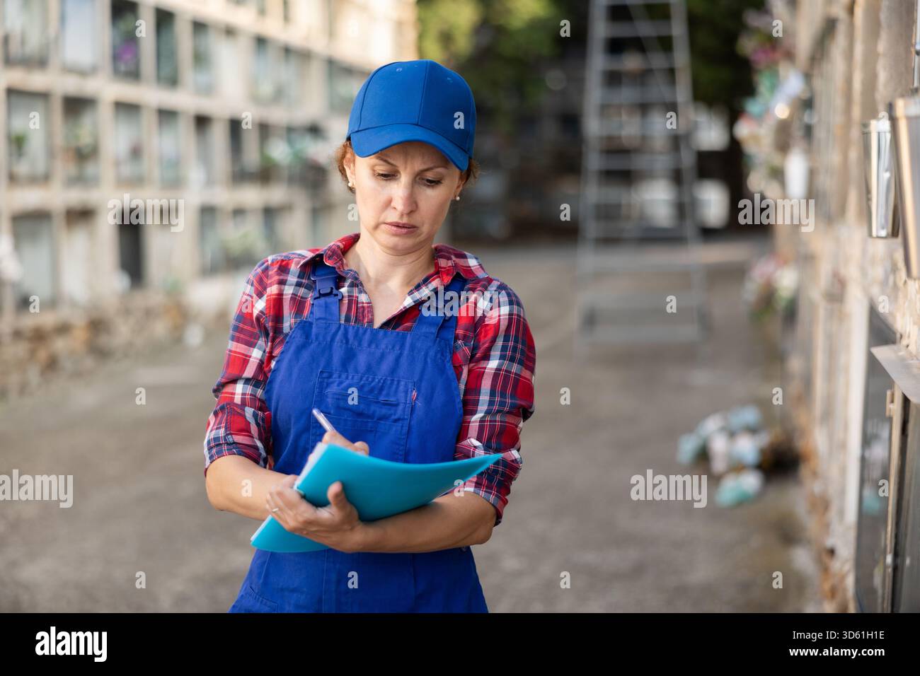 Female cemetery worker writing notes by columbarium Stock Photo - Alamy