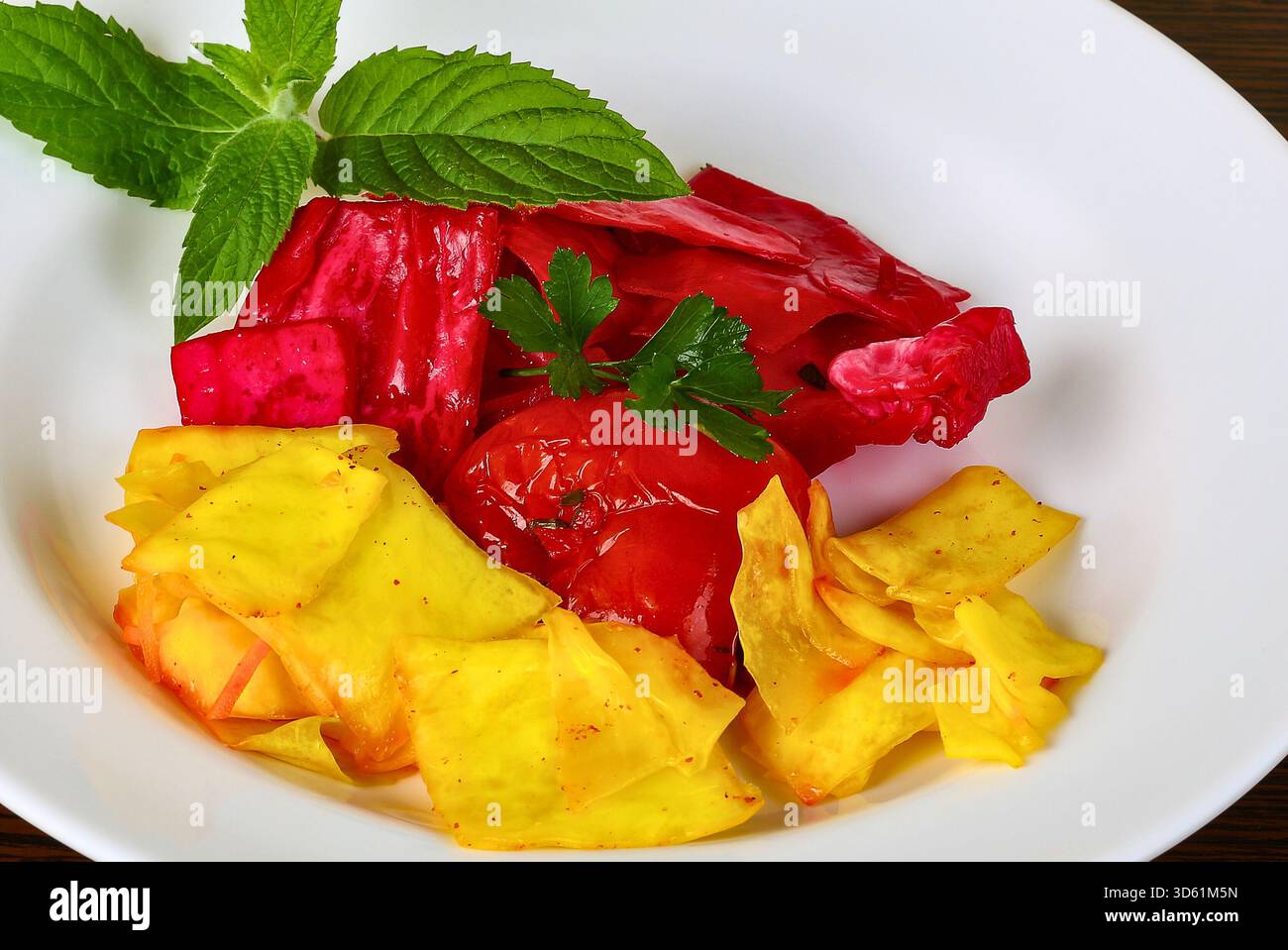 A close-up shot of bright red and yellow pickled vegetables served on a ...