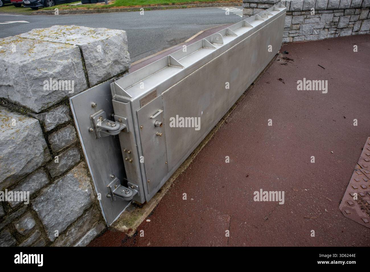 metal flood barrier panel fixed between stone walls on a pavement Stock ...