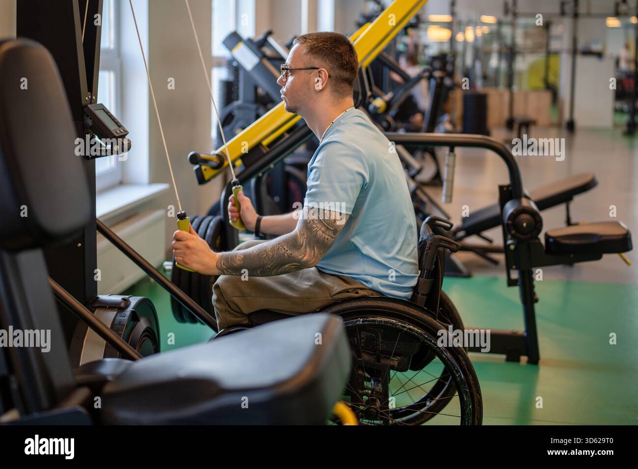 Man in wheelchair doing vertical pulls with arms at rehabilitation ...