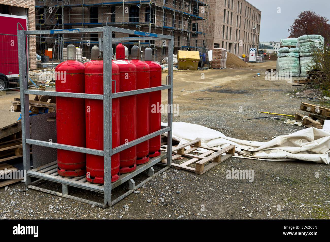 Red propane tanks standing in metal cage on construction site with new ...