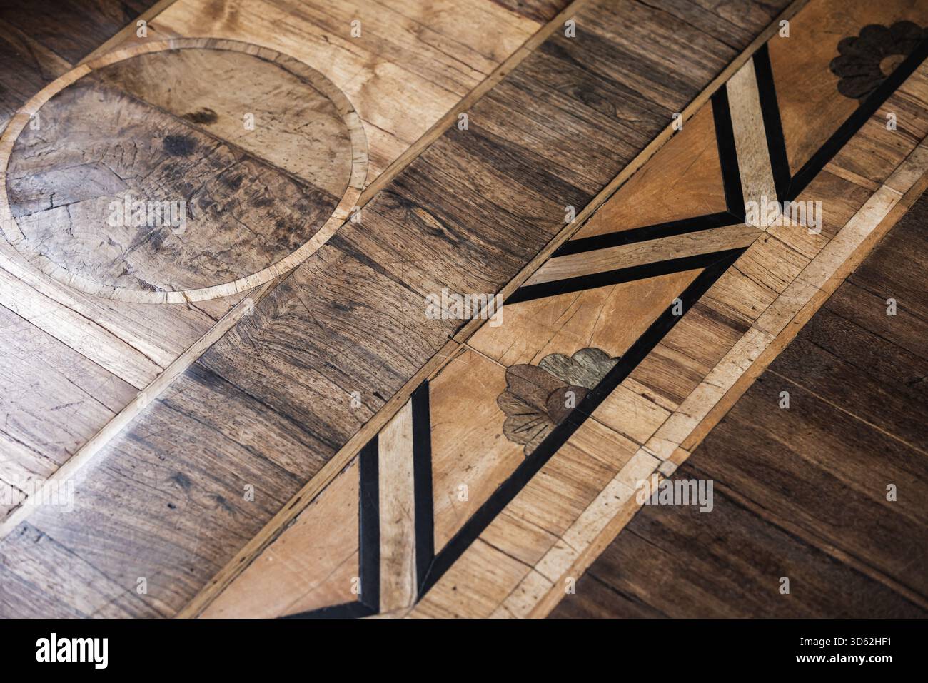 Aged wooden parquet floor featuring a circular inlay and a bold ...
