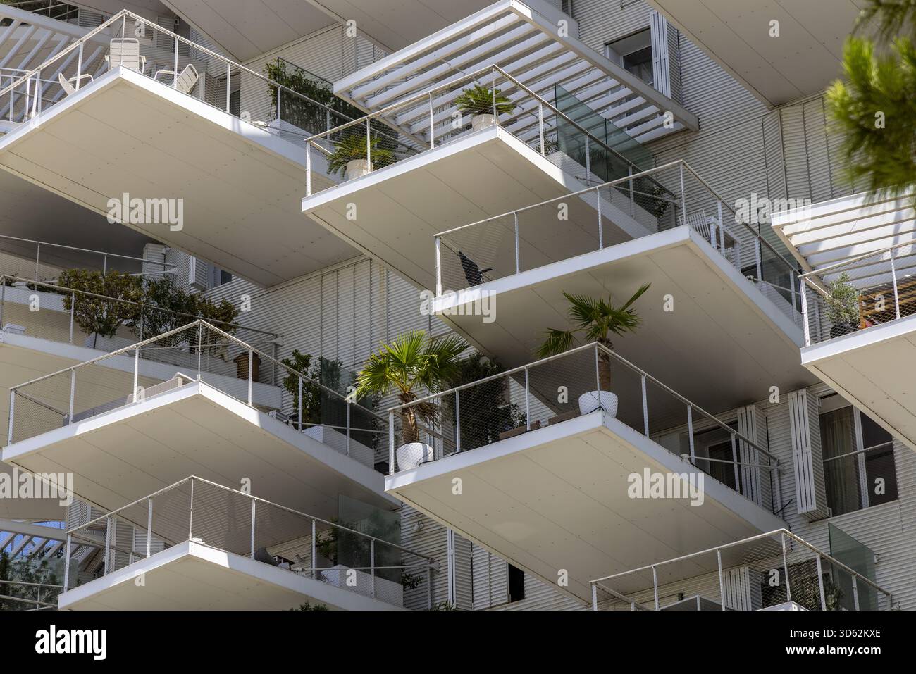 View of staggered balconies adorned with lush greenery jut from a ...