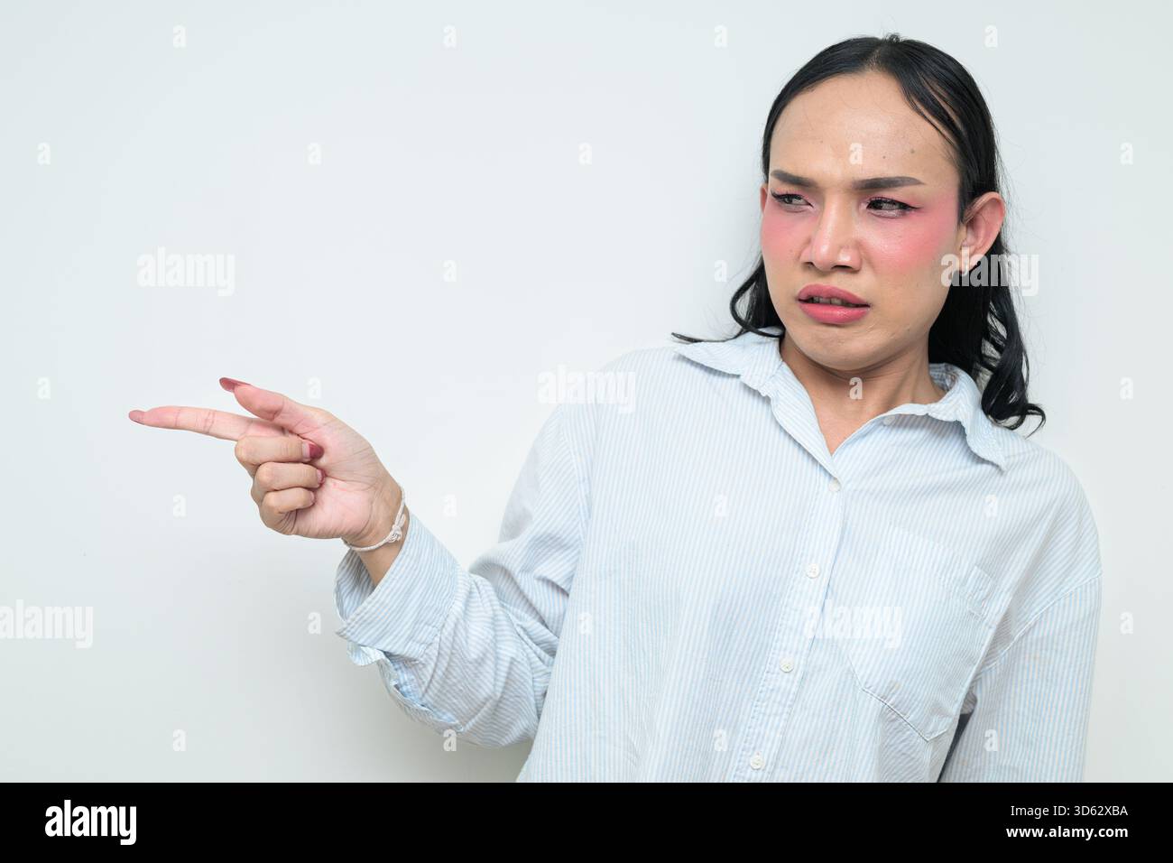 Studio portrait of a young Thai transgender individual with makeup and ...