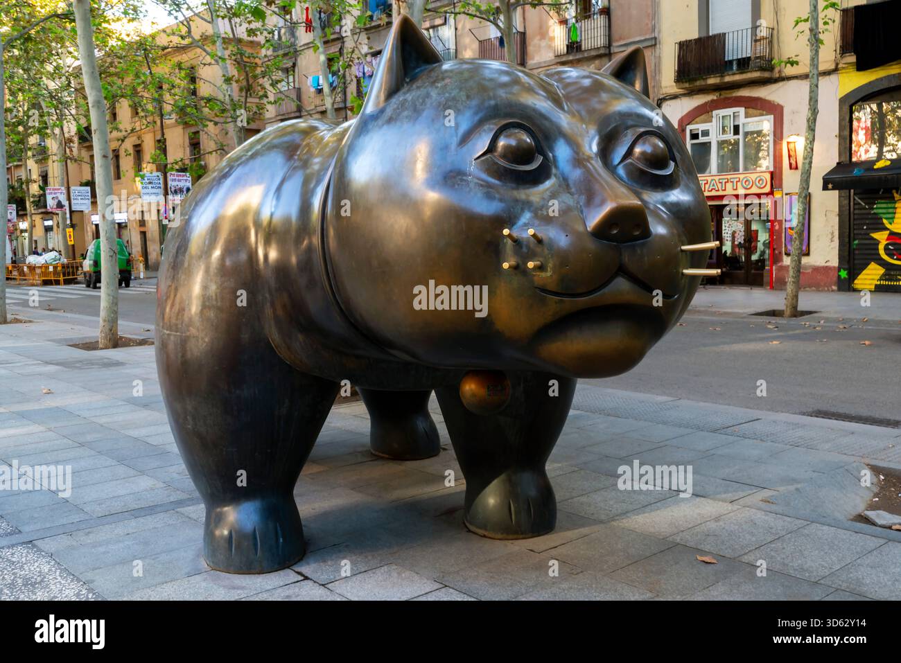 A monumental bronze sculpture of a cat with a playful expression ...