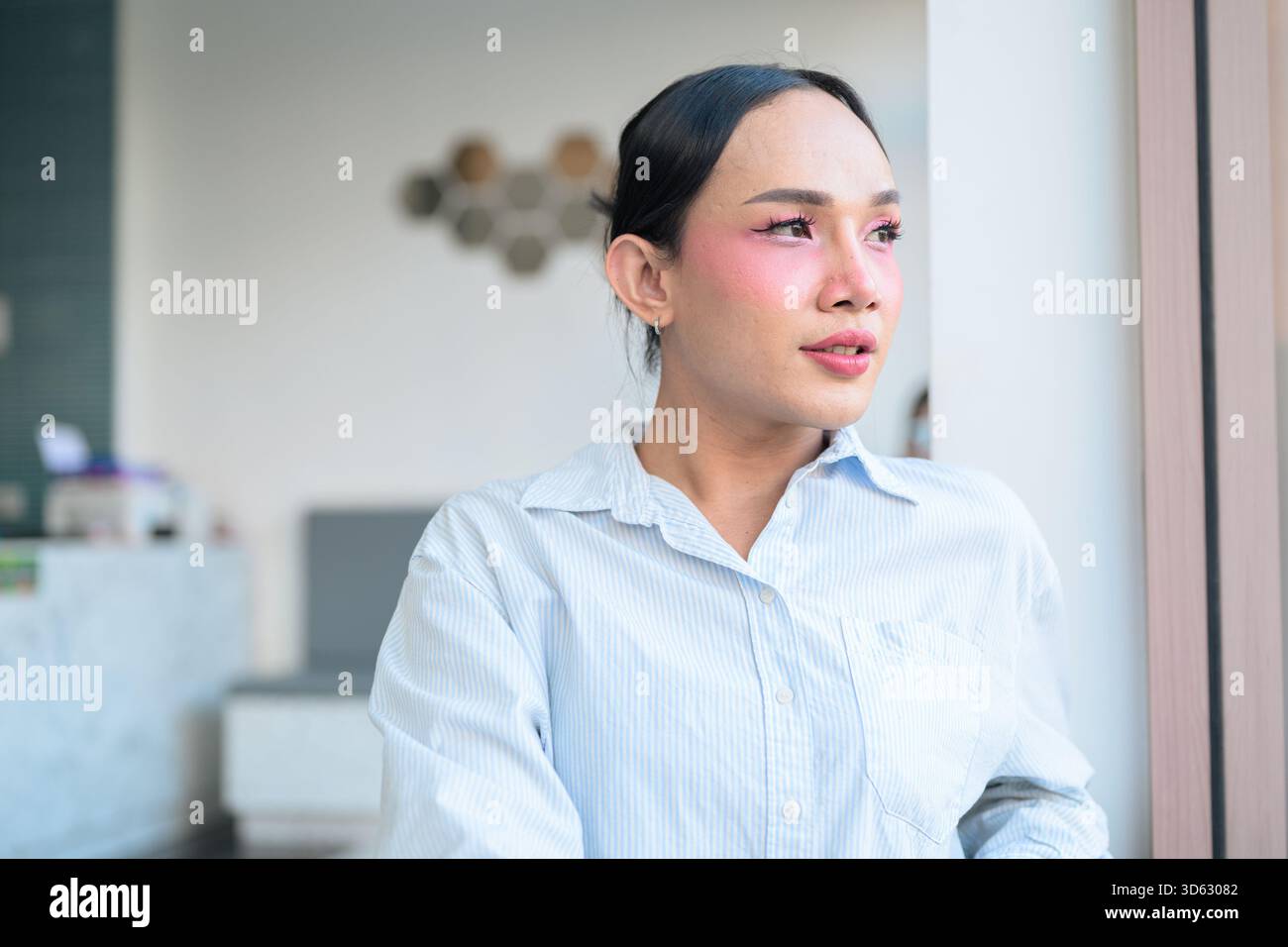 Portrait of a young Thai transgender individual with makeup and long ...