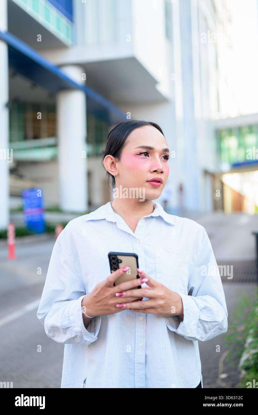 Portrait of a young Thai transgender individual with makeup and long ...