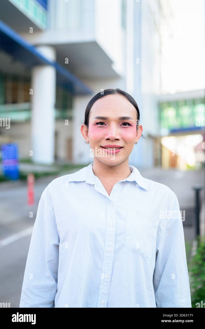 Portrait of a young Thai transgender individual with makeup and long ...