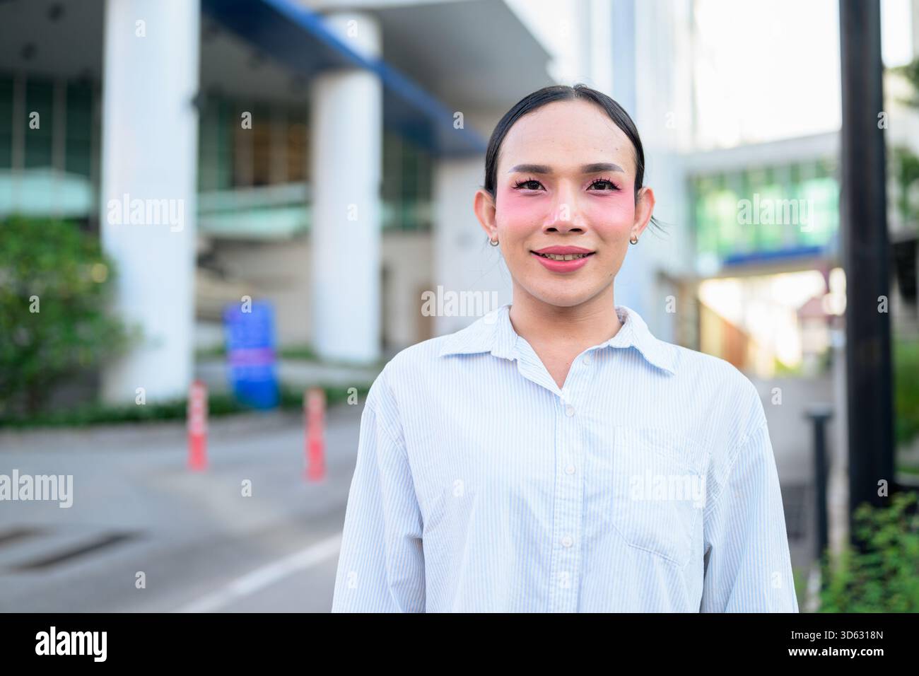 Portrait of a young Thai transgender individual with makeup and long ...