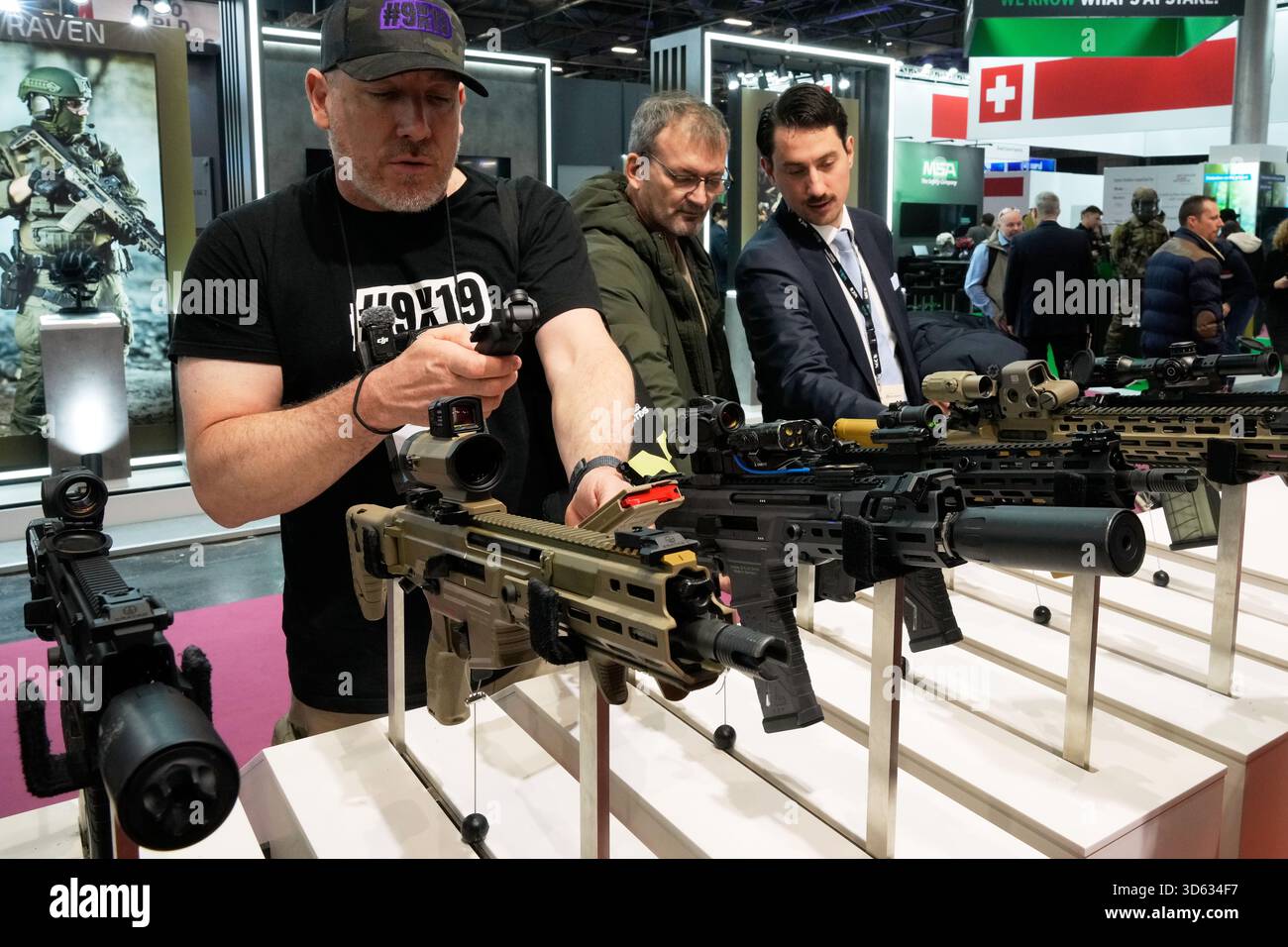 Visitors check weapons at the German company Heckler and Koch stand ...