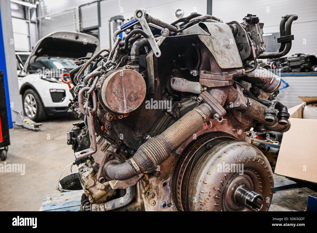Disassembled vehicle engine showing mechanical parts on a palette in a ...