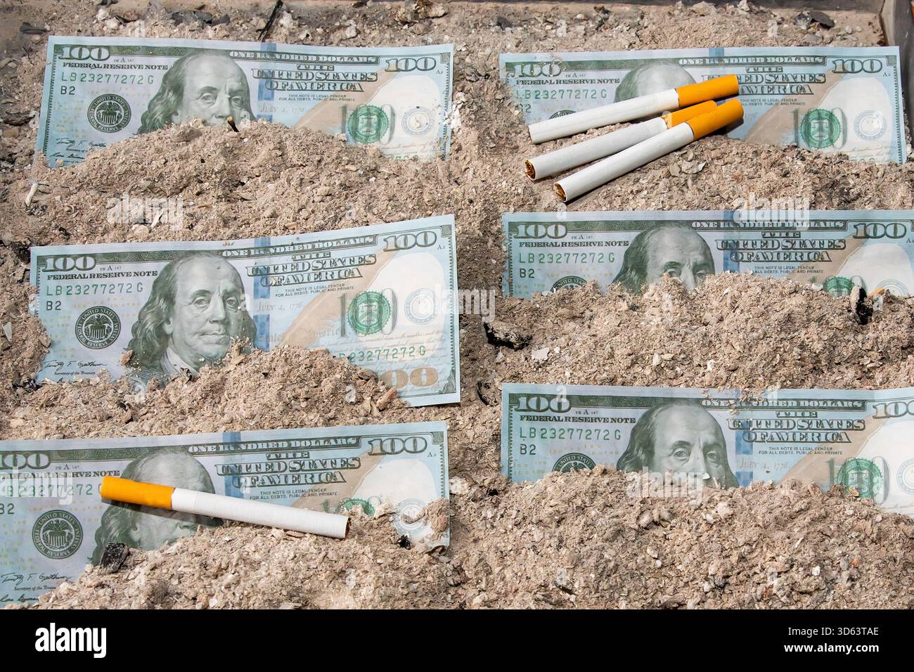 Hundred dollar bills and cigarettes in ashes creating concept of money ...