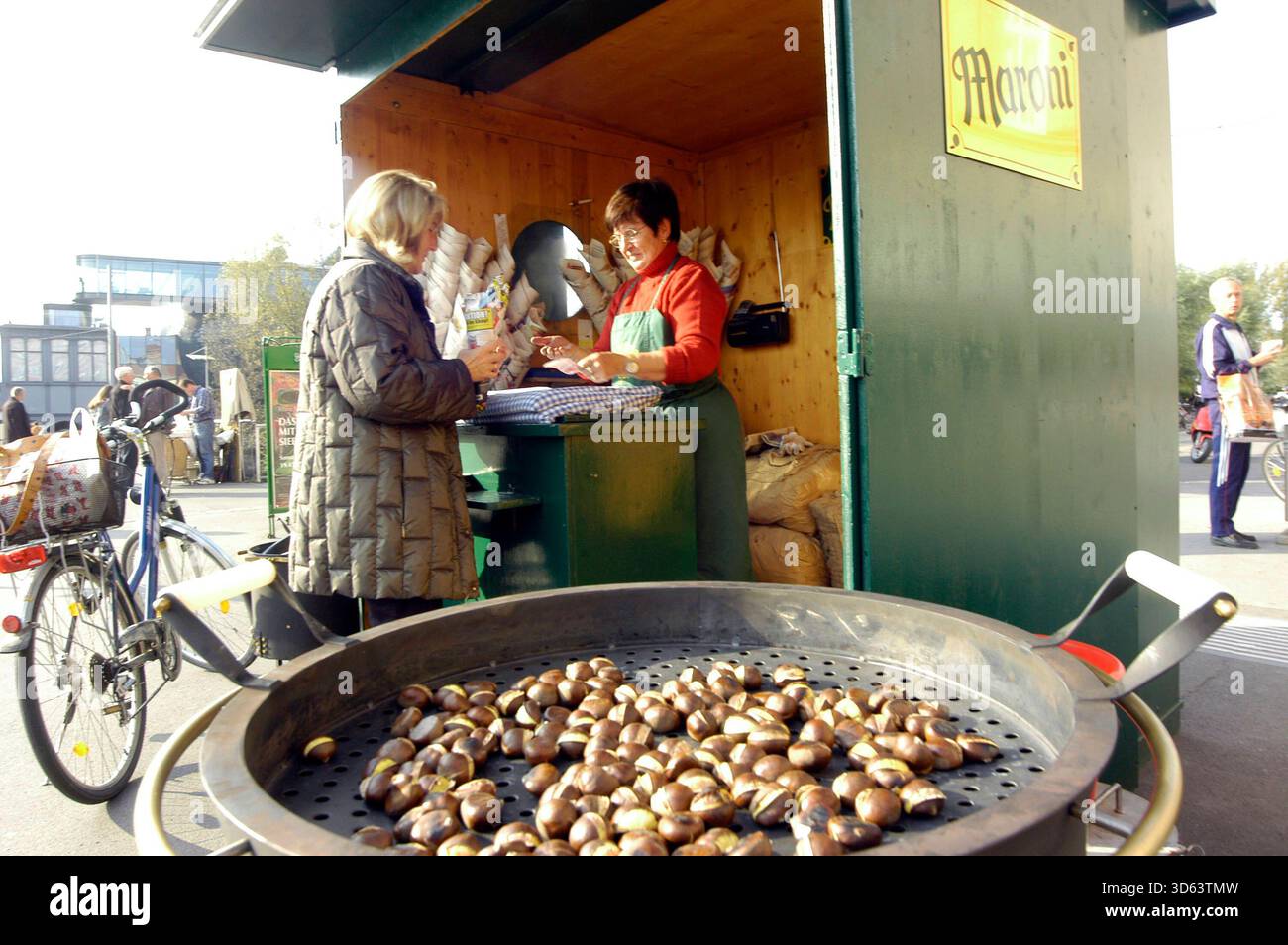 a chestnut vendor roasting chestnuts, delicious edible nuts with brown ...