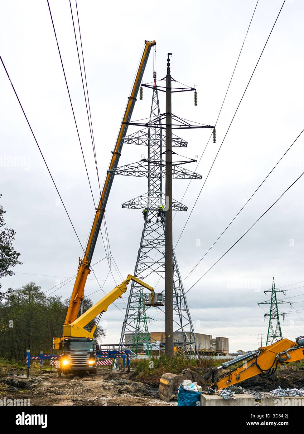 Electrical engineers and cranes assemble a high-voltage power ...