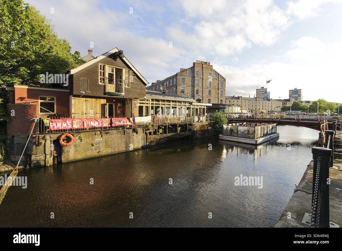 View of calm waters reflect the buildings and sky, a restaurant on the ...