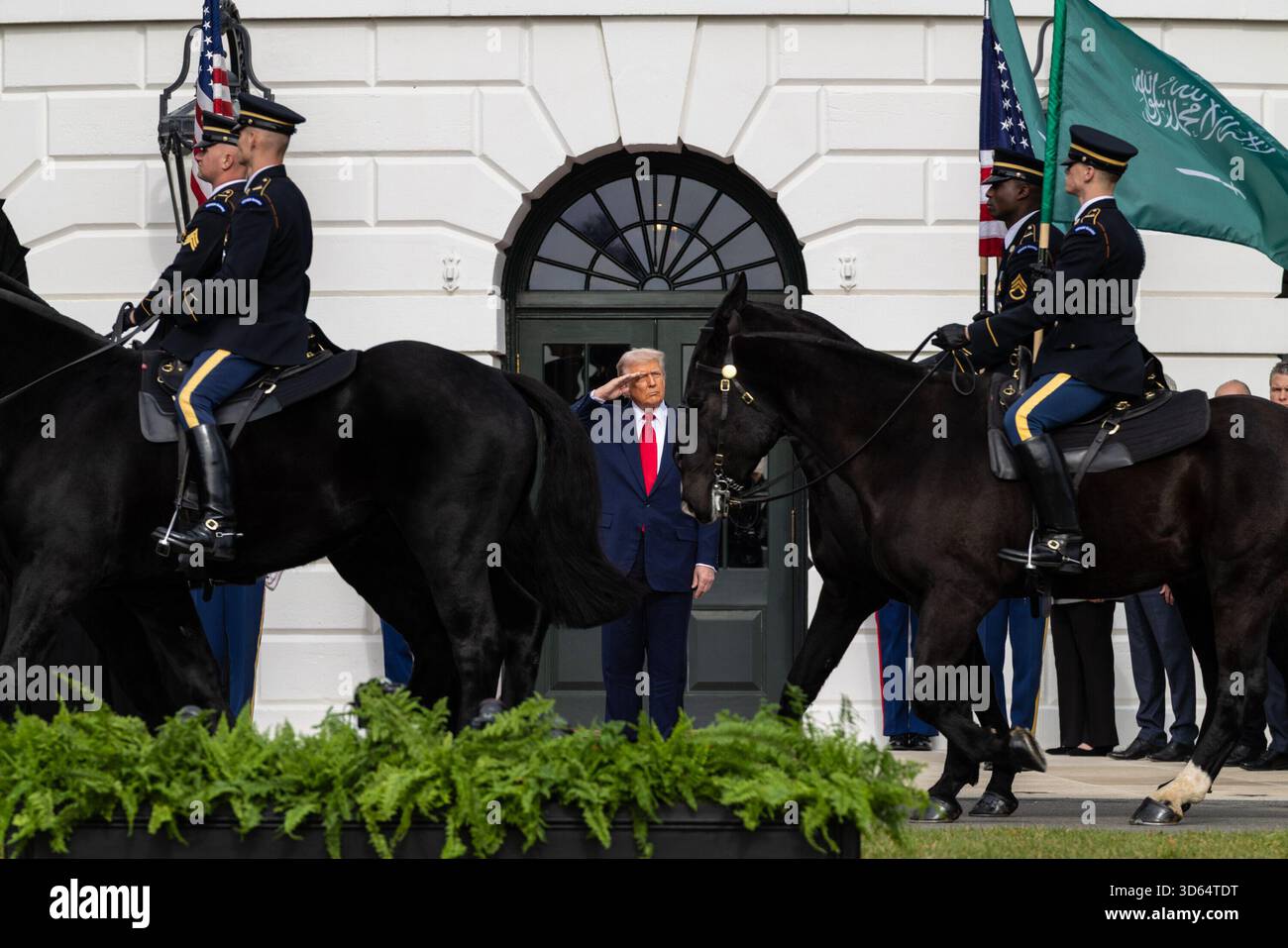 United States President Donald J Trump salutes as he awaits the arrival ...
