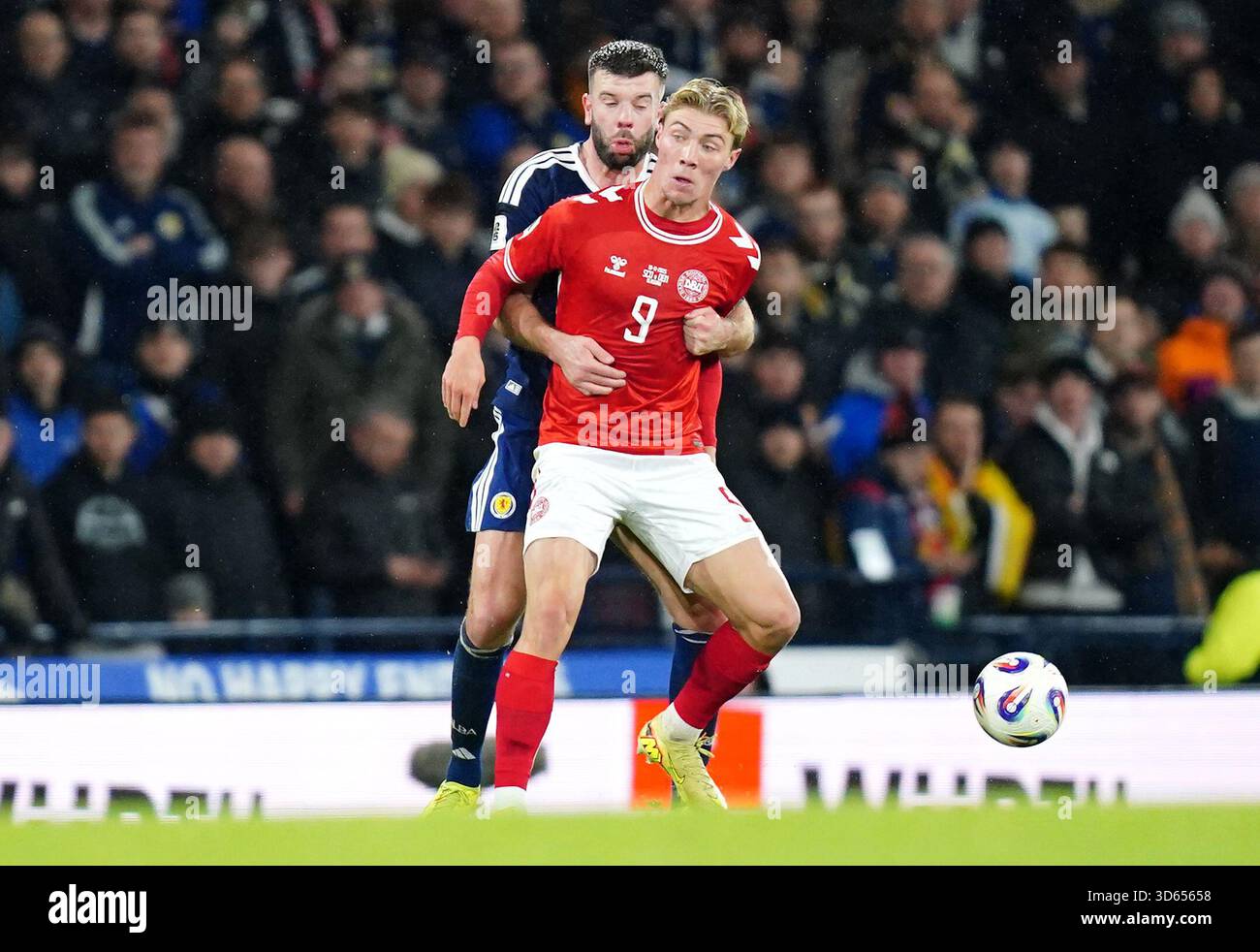 Denmark's Rasmus Hojlund (right) and Scotland's Grant Hanley battle for ...