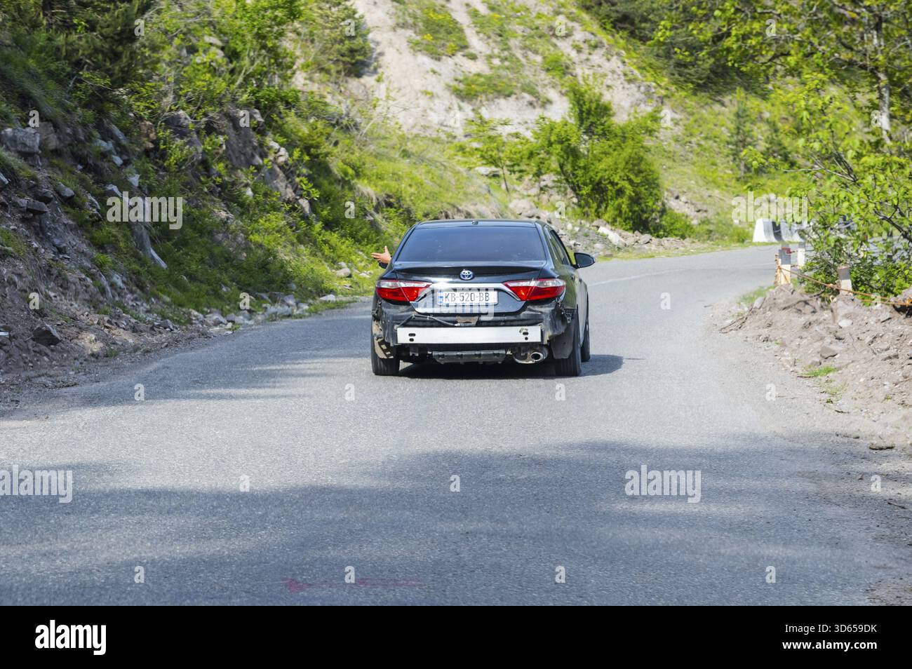 Black car driving on a winding road through the countryside, car ...