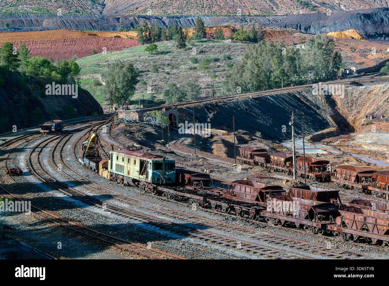 Numerous rusting railway carts and mining equipment lay abandoned along ...